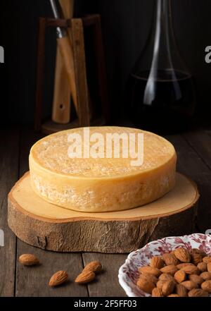 Moody brazilian Canastra artisanal cheese with slices over a wooden ...