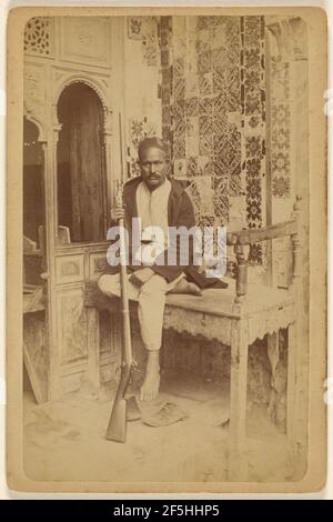 Arab male seated, holding a rifle, with shoes off, Unknown, about 1880 ...