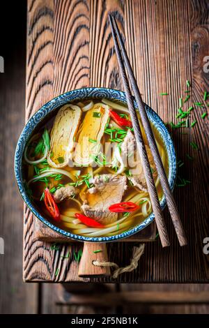 Delicious Thai broth in black bowl with chopsticks Stock Photo - Alamy
