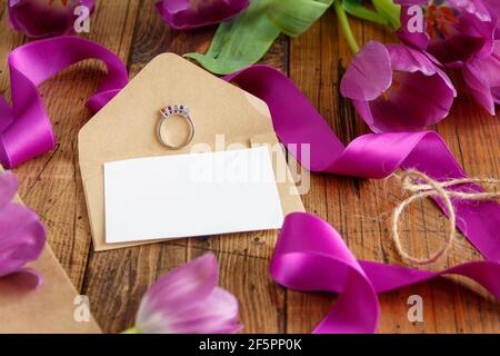 Purple tulips, ring and blank card on wooden table close up Stock Photo ...
