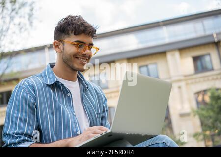 Portrait Indian student programmer using laptop computer in park Stock ...