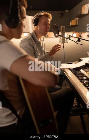 Men creating music in studio together Stock Photo - Alamy