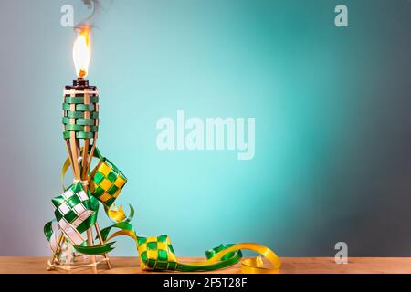 Traditional Malay torch and decorative ketupat lit up during Hari Raya ...
