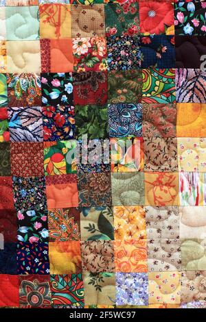 Patchwork background. A fragment of multi-colored pieces of fabric sewn ...