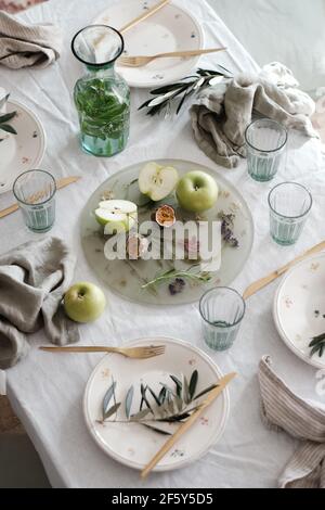 Table setting. White plates, cutlery, napkin and mistletoe Stock Photo ...