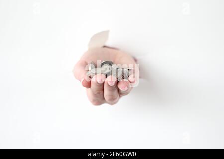 Hand pulling out bunch of coins from torn paper Stock Photo - Alamy