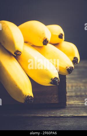 Branch of bananas on the rustic background. Selective focus. Shallow ...