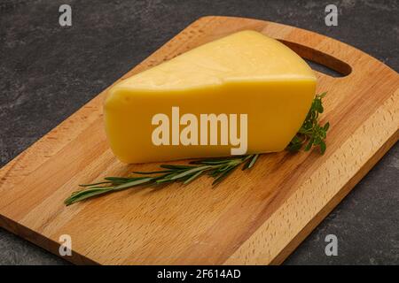 Hard cheese piece served rosemary and basil Stock Photo - Alamy