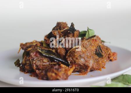 Kerala style mutton roast prepared with coconut oil. Shot on white ...