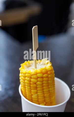 An ear of boiled corn in a paper cup. Fast food concept Stock Photo - Alamy