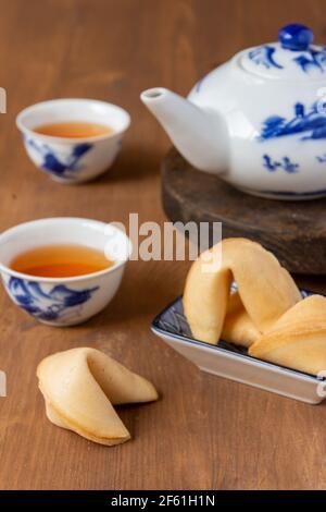 Plate with fortune cookies, teapot, cups and Chinese symbols on color ...