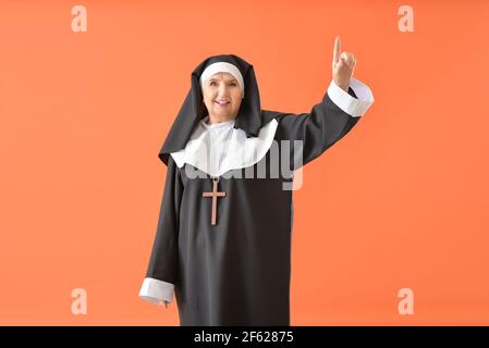 Senior nun pointing at something on light background Stock Photo - Alamy
