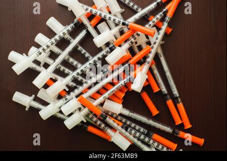 Pile of Medical syringes on wooden background Stock Photo - Alamy