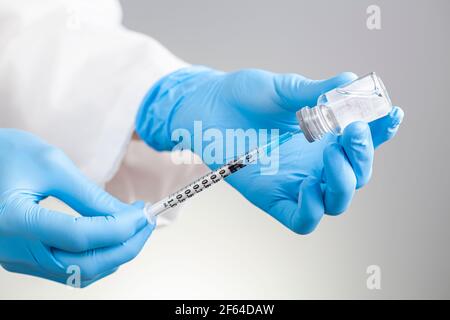 Doctor sucking an injection drug from a vial bottle Stock Photo - Alamy