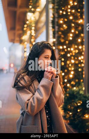 Woman by illuminated showcase on city street Stock Photo - Alamy