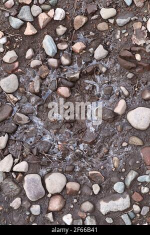 Natural winter background of frozen pebbles and hoarfrost crystals over ...