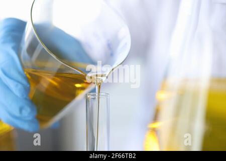 Scientist chemist pouring oil from flask into glass closeup Stock Photo ...