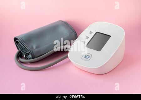 Automatic blood pressure monitor on pink background banner. Medical ...