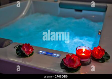 Hot tub with candles and water lilies Stock Photo - Alamy