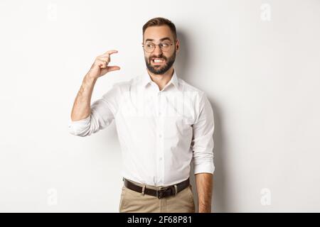 Displeased bearded businessman showing small gesture, looking ...