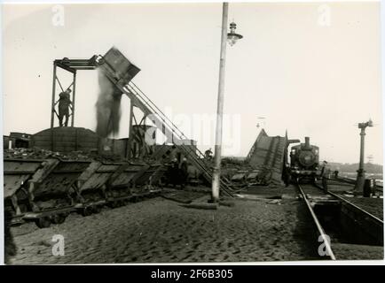 Tipping ash from the steam locomotive over to freight wagons Stock ...