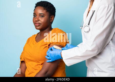 Nurse Applying Bandage After Vaccine Injection To Patient, Blue ...