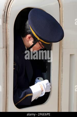 A train conductor in Japan checking the bullet train is ready to leave ...