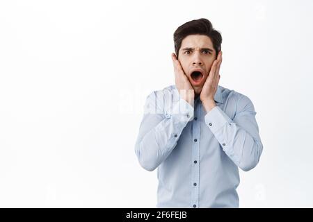 Frustrated and shocked guy panicking, screaming and looking scared ...