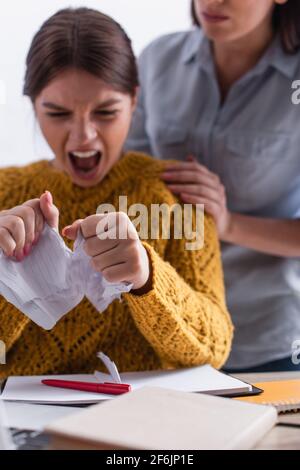 angry teen girl tearing notebook paper while doing homework Stock Photo ...