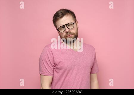 Portrait of attractive suspicious funny man demonstrating aside copy ...