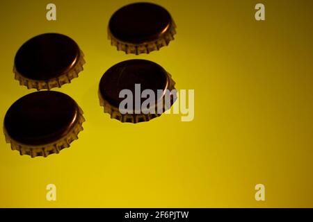 beer caps on yellow background Stock Photo - Alamy