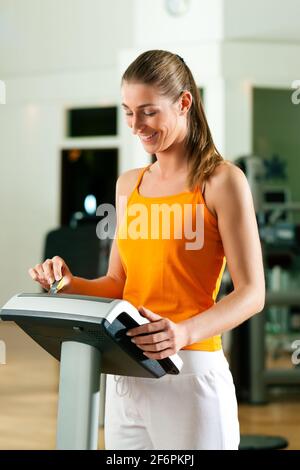 Woman reading her training program in a gym Stock Photo - Alamy