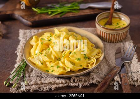 Homemade tortellini with delicious cheddar sauce and herbs Stock Photo - Alamy