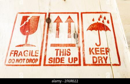 Bright red special marking symbols on wooden boxes with goods inside ...