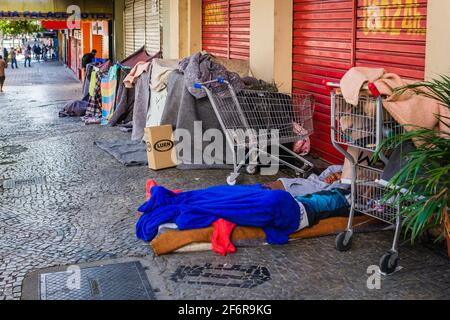 Brazilian homeless couple sleeping on a mattress on the sidewalk of a ...