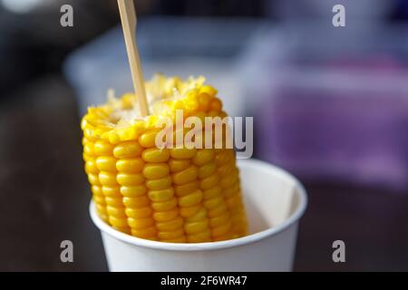 An ear of boiled corn in a paper cup. Fast food concept Stock Photo - Alamy