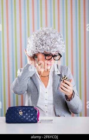 Beautiful female secretary applying makeup in office Stock Photo - Alamy