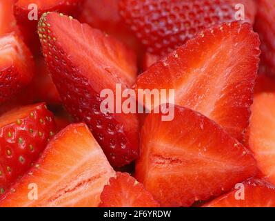 Crop of red ripe strawberries collected in two plastic crates on wooden ...