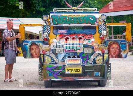 Filipino Jeepney, decorated with painted images of Jesus Christ and ...