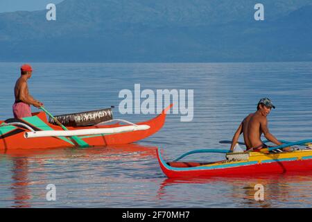 Filipino fishermen preparing to take their outrigger canoes out to fish ...