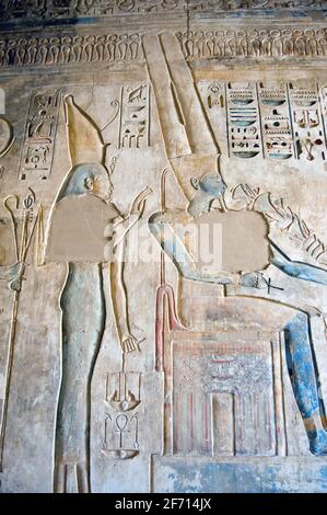 The Ancient Egyptian goddess Isis seated on a throne holding her ...