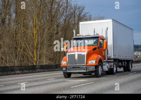 Industrial bright orange day cab big rig semi trucks and dry van semi ...