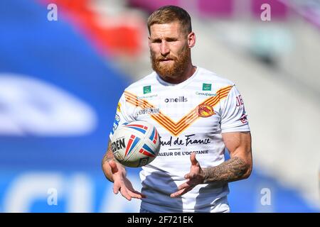 Sam Tomkins (29) of Catalans Dragons is held up by Lewis Dodd (21) and ...