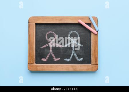 Chalkboard with drawn human figures on wooden background. Concept of ...