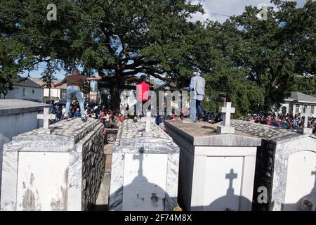 Young men dance atop tombs during a vibrant second line procession ...
