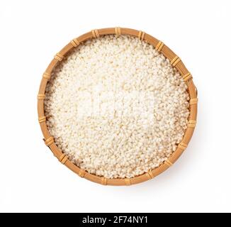 Glutinous rice in a bamboo colander set against a background of trees ...