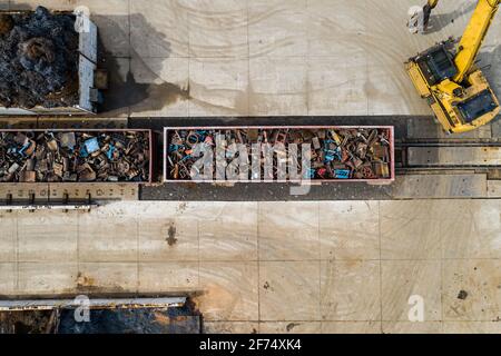 Scrap metal recycling loading into containers top view from the throne ...