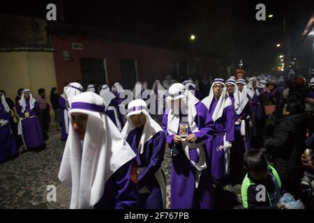Cucuruchos in purple robes process solemnly through the streets of ...