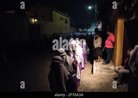Cucuruchos in purple robes process solemnly through the streets of ...