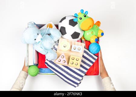 Donations box with kid toys, books, clothing for charity on colorful ...